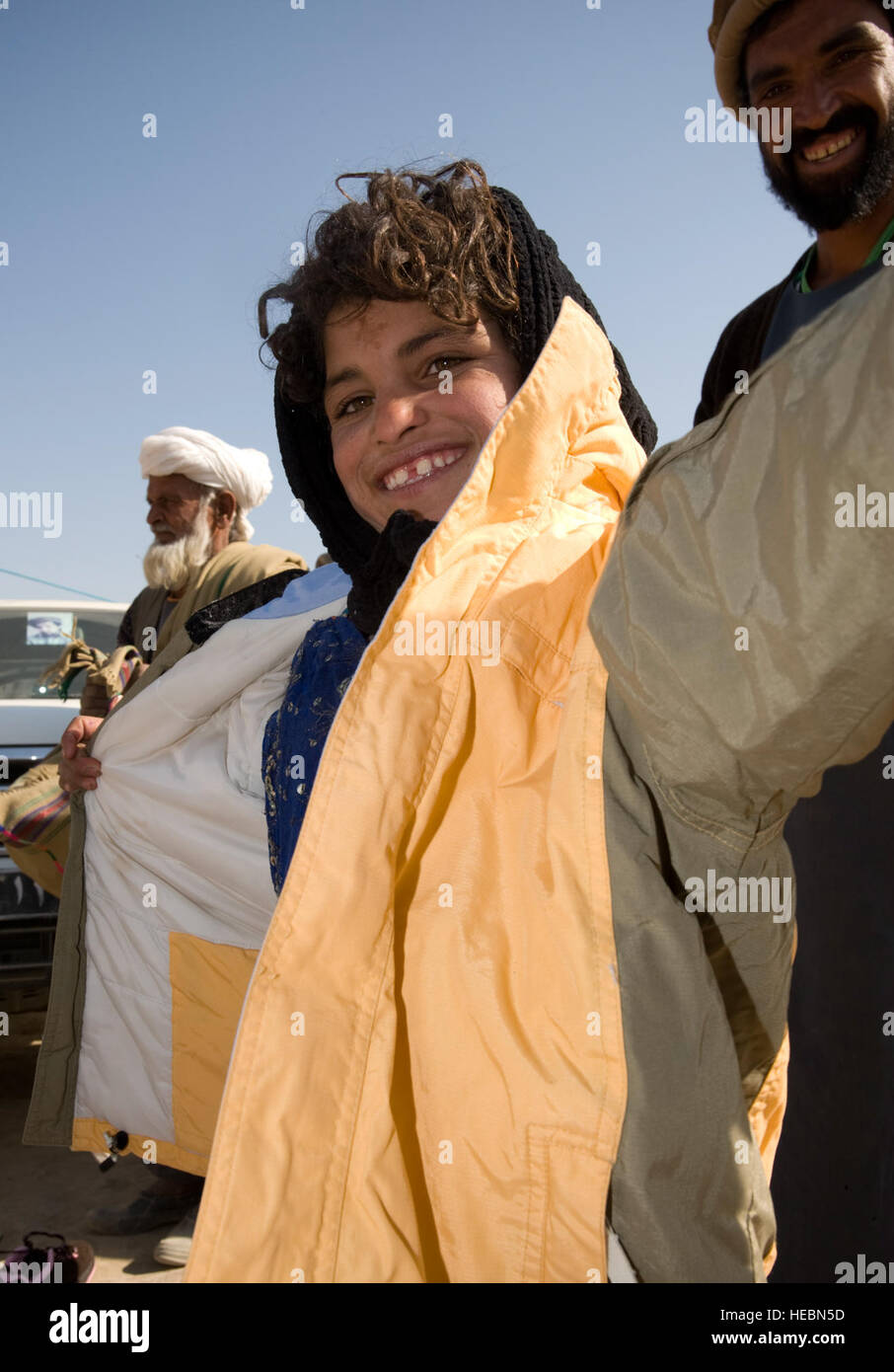 An Afghan girl tries on coat during a humanitarian assistance visit to ...