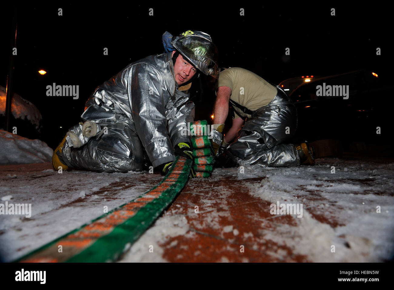 Firefighters condense a hose after completing a simulated bomb ...