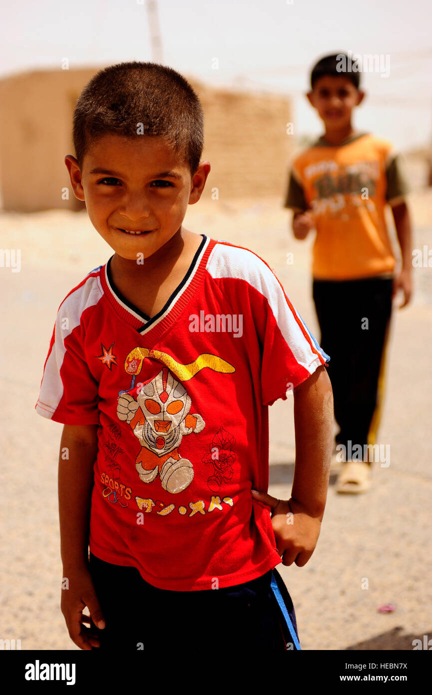 An Iraqi boy stops to pose for a photo while playing in the street, in ...