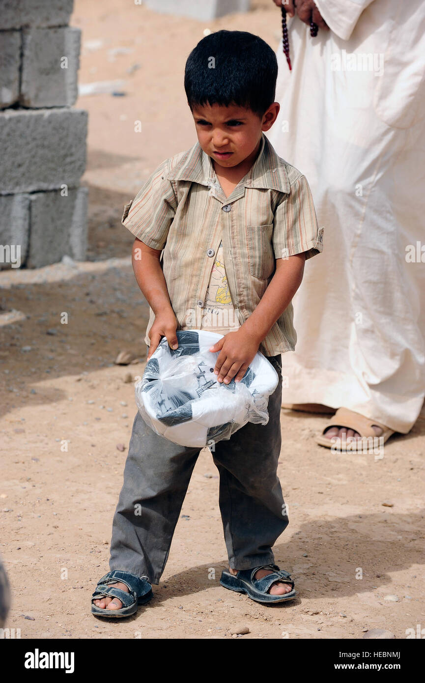 An Iraqi child stands with his new soccer ball as he watches U.S. Army ...
