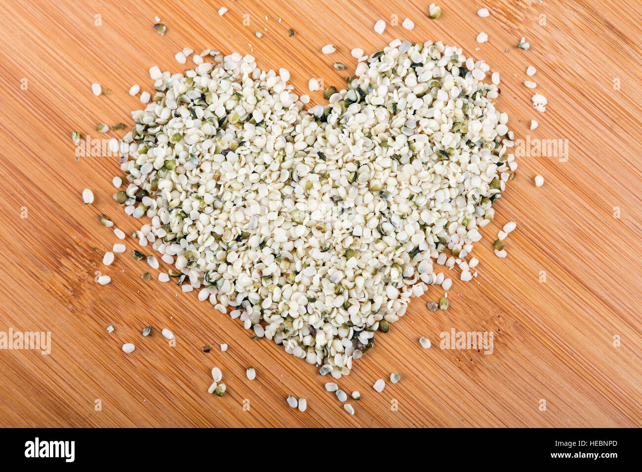 Heart shaped pile of hemp hearts isolated on wood background Stock ...