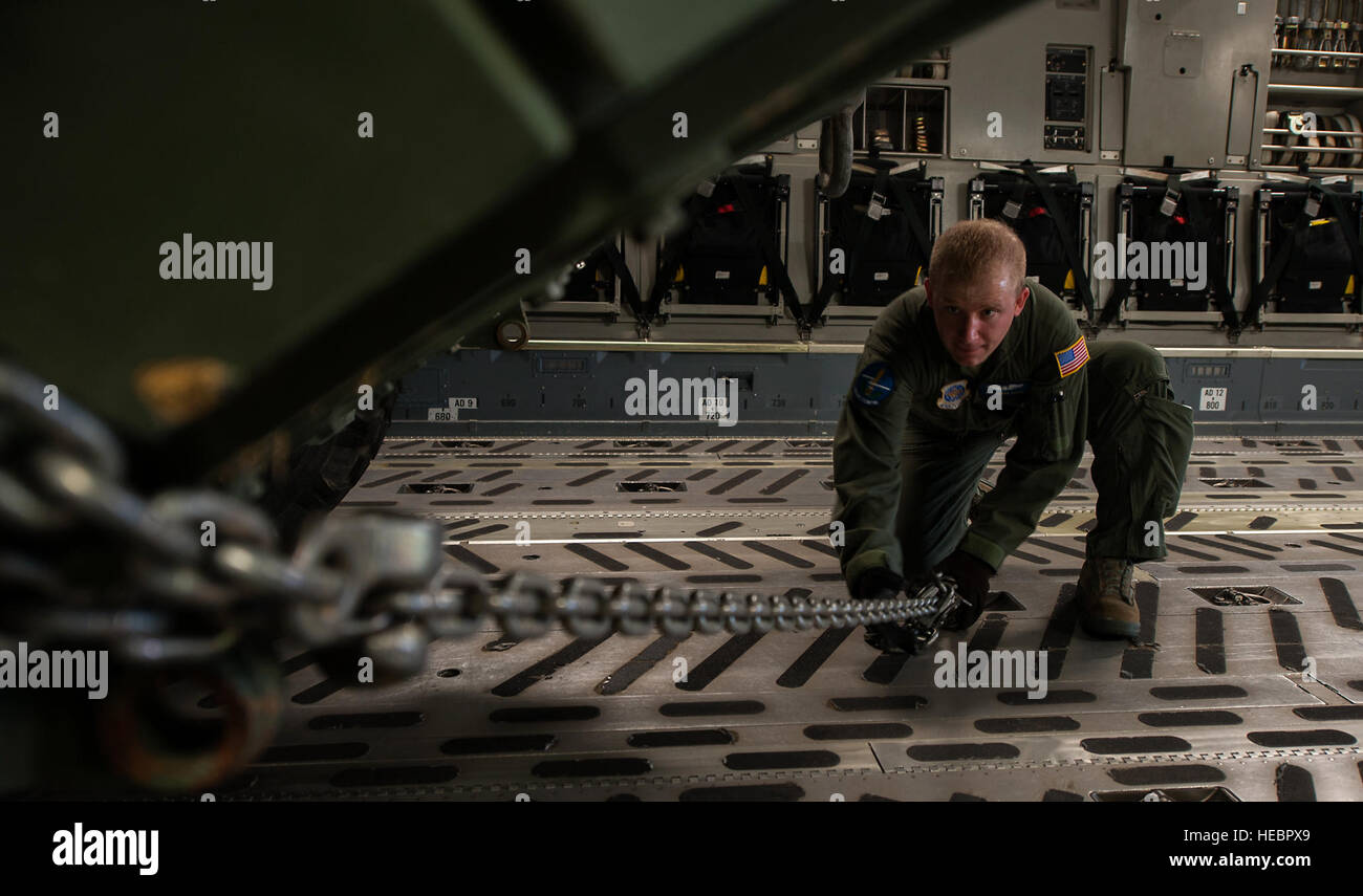 A U.S. Air Force loadmaster secures a U.S. Army Stryker inside a C-17 ...