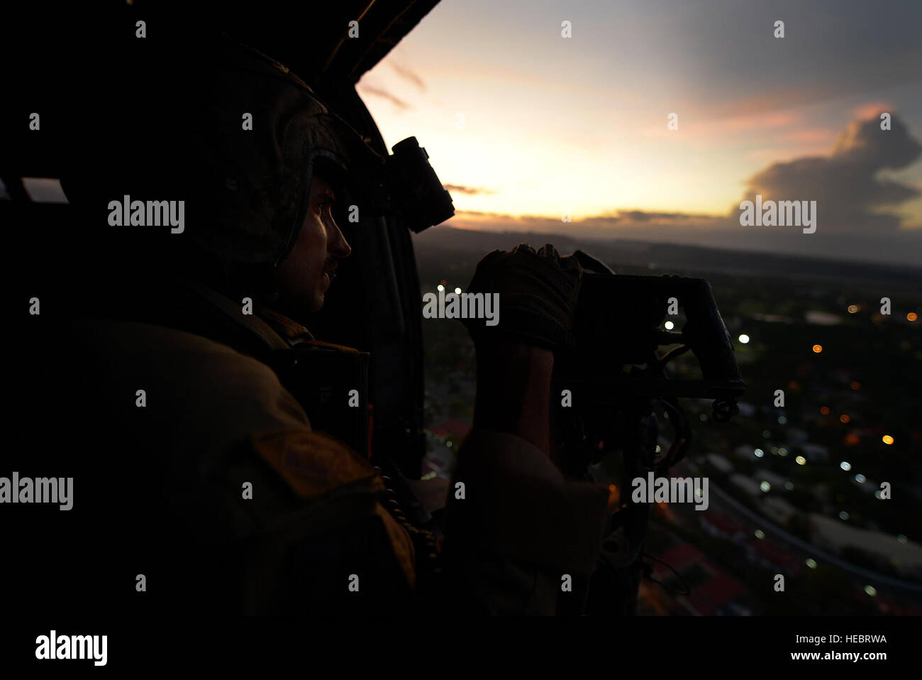 A U.S. Navy SH-60 Seahawk helicopter door gunner looks out over the ...