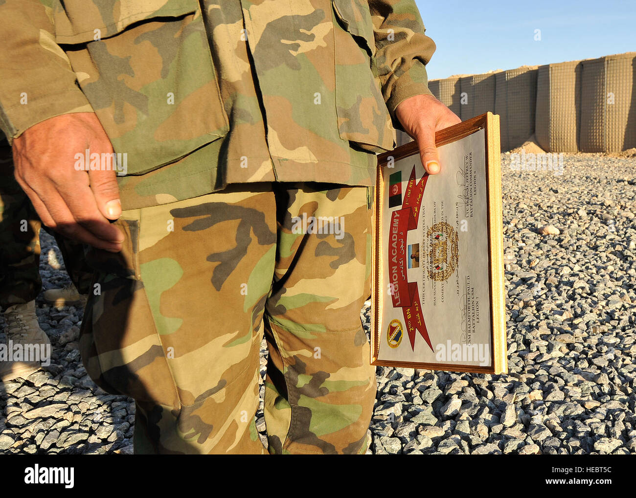 An Afghan national army soldier stands at attention while holding his ...
