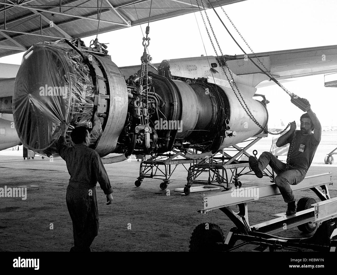Two technicians stand by while a Boeing 707 aircraft engine is ...