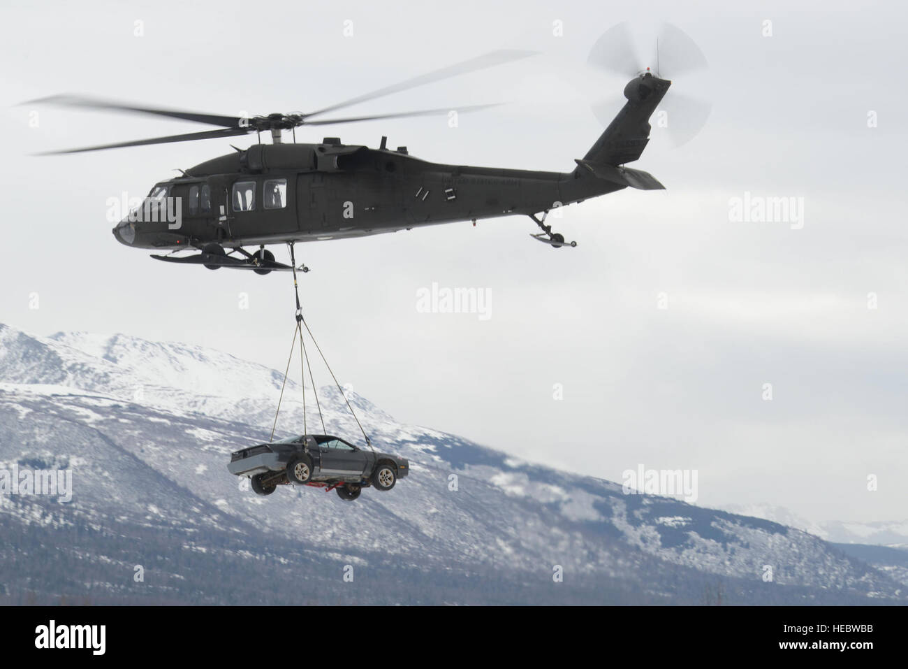 A UH-60 Black Hawk helicopter transports a car during a sling load ...