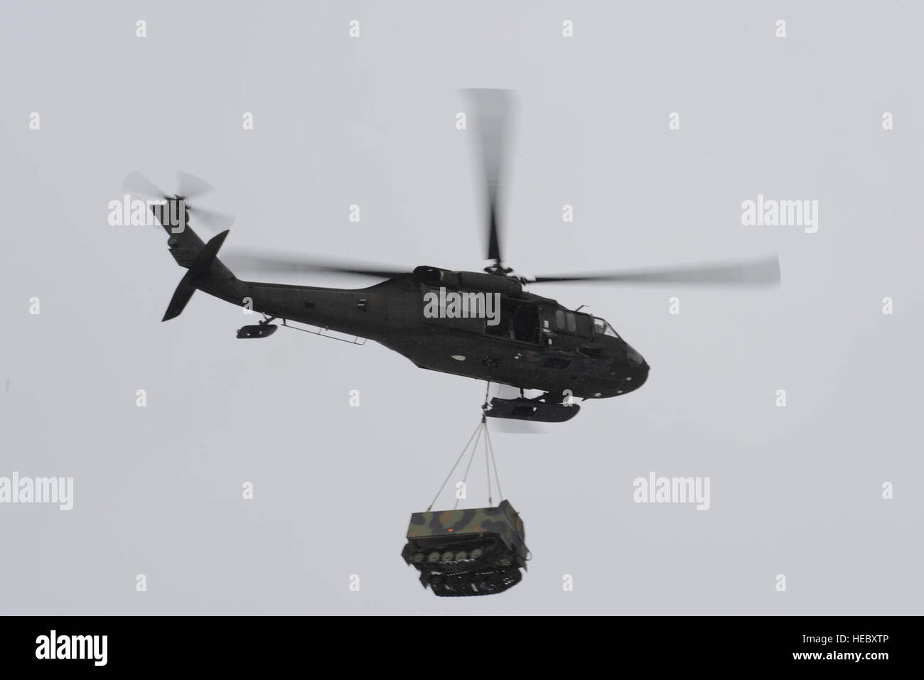 A UH-60 Black Hawk helicopter transports a car during a sling load ...