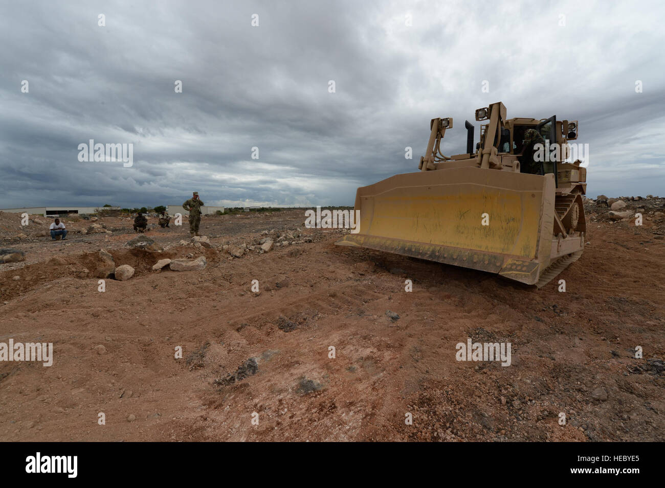 U.S. Navy Seabees demonstrate how to operate a tractor to members of ...