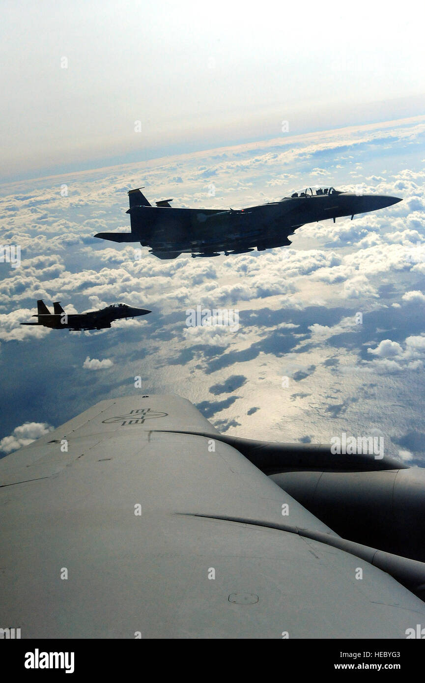 Two F-15E Strike Eagles fly alongside a KC-135R Stratotanker during ...
