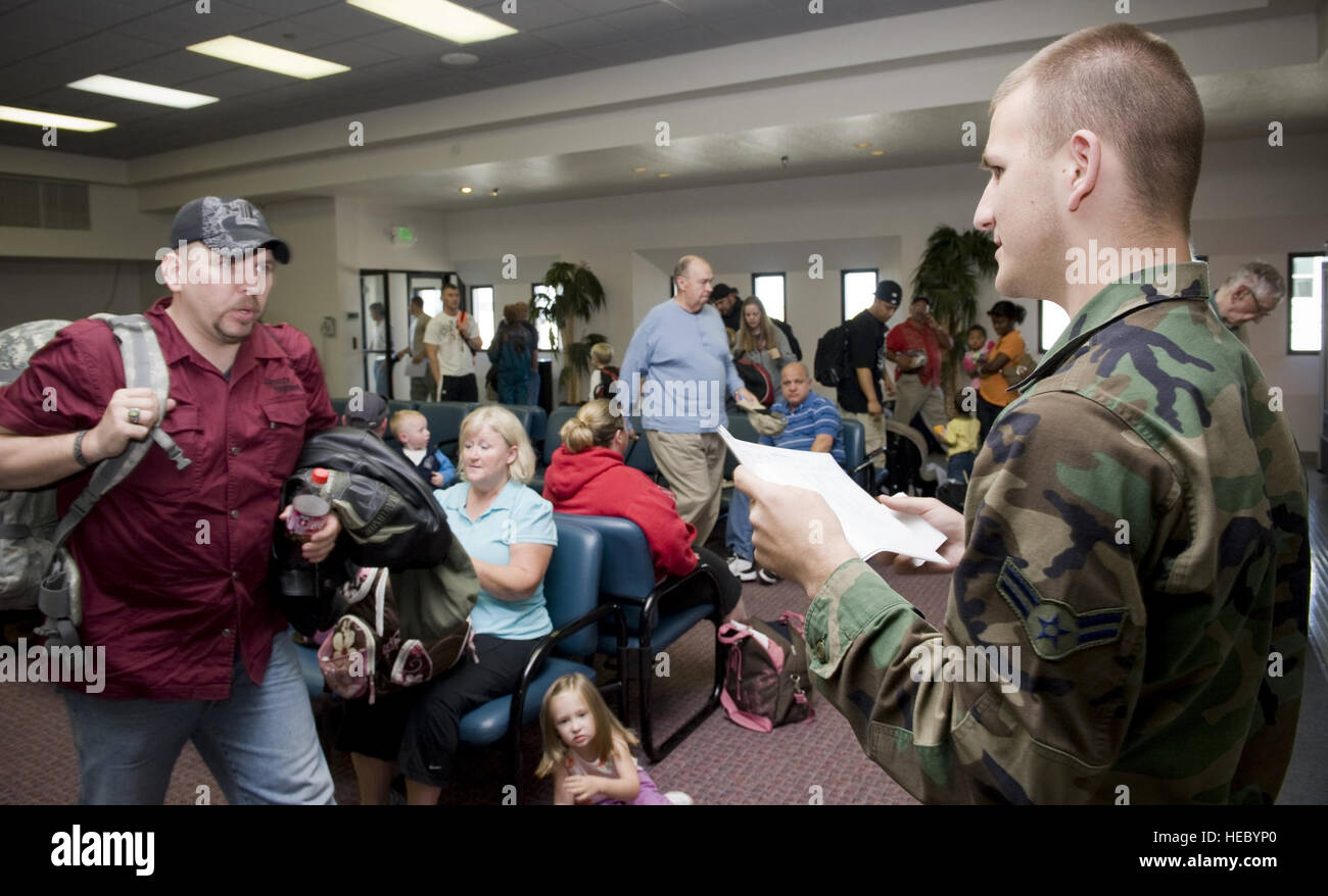 Airman 1st Class Wade Helms calls the names of travelers to board a bus ...