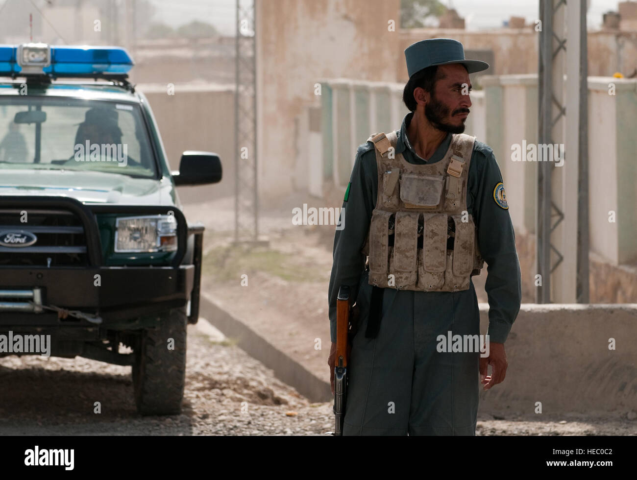 An Afghan National Police officer diverts traffic during a combined ...