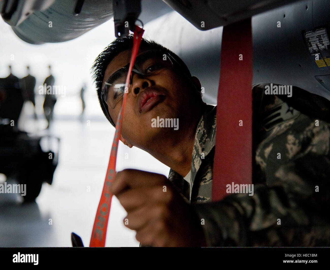 A U.S. Air Force airman inspects the load of a guided bomb unit on an F ...