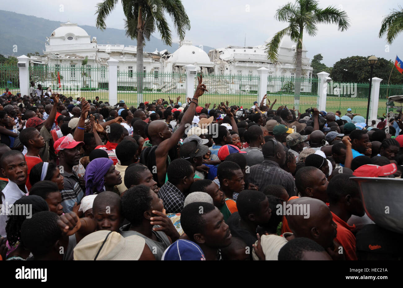 A crowd of Haitians gathers for food distribution in front of the ...