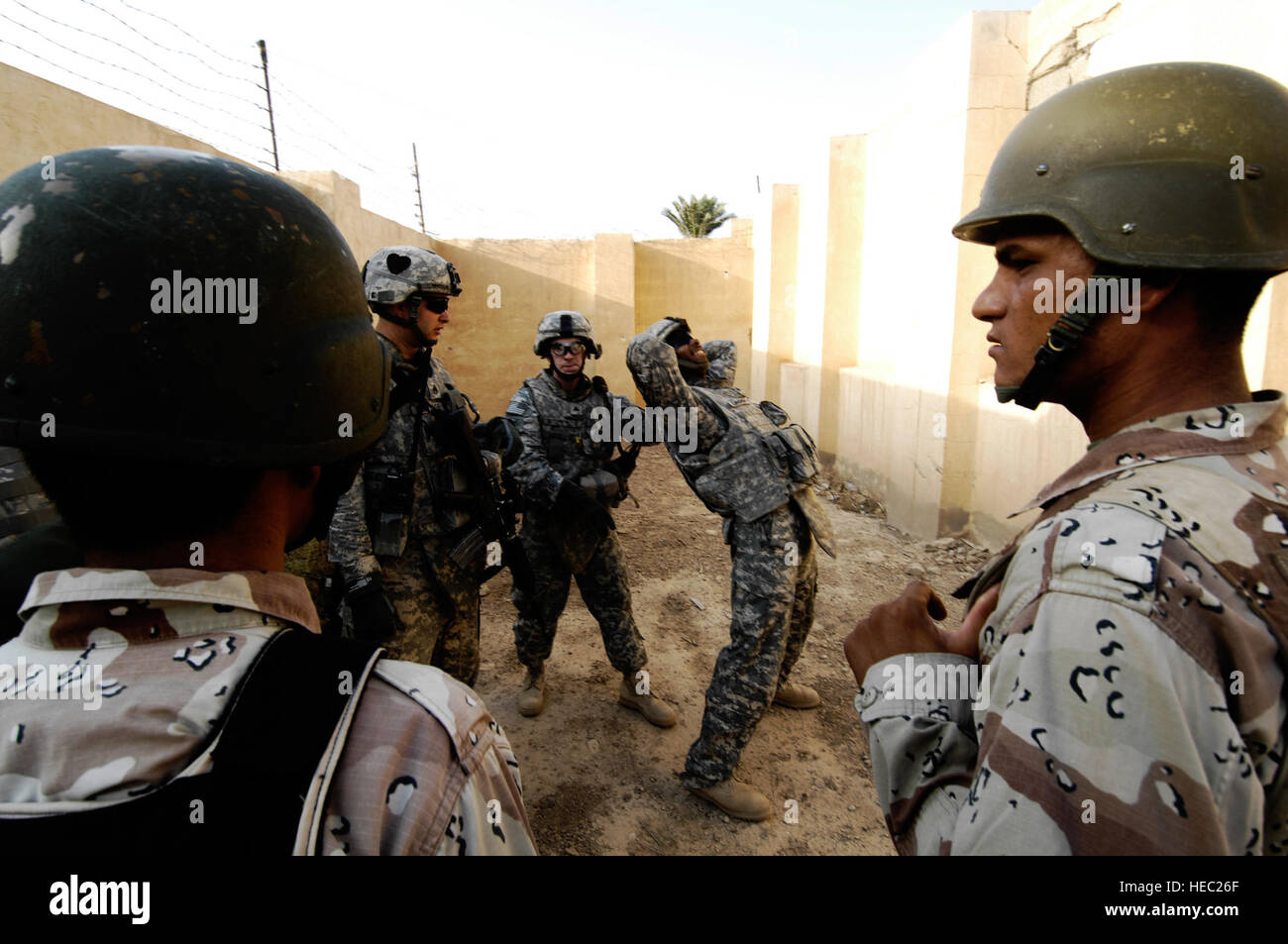 U.S. Soldiers demonstrate individual searching procedures to two Iraqi ...