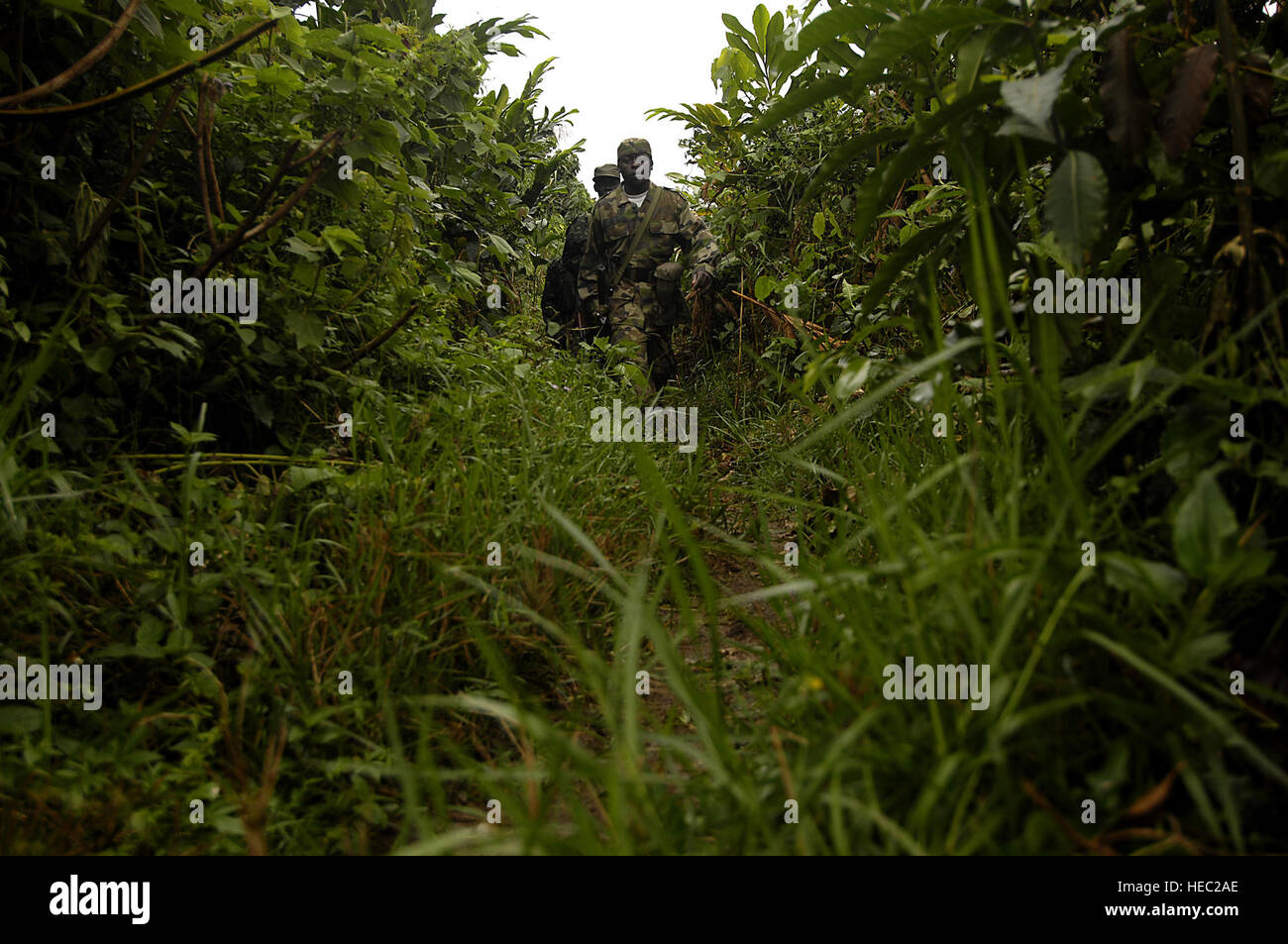 Using a compass, Uganda Army soldiers search the terrain for markers ...