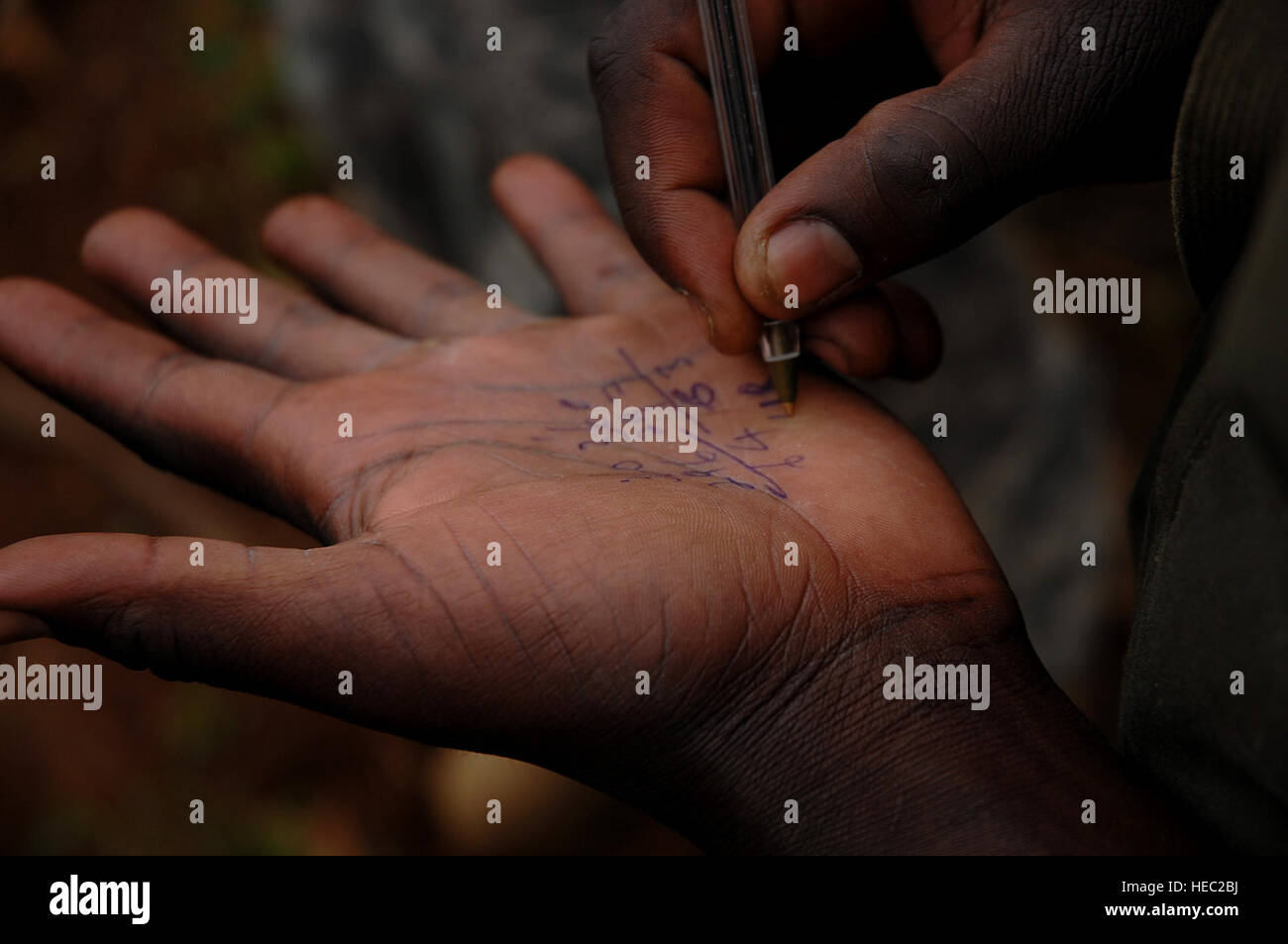 A Uganda Army soldier uses his hands for notes while plotting his ...