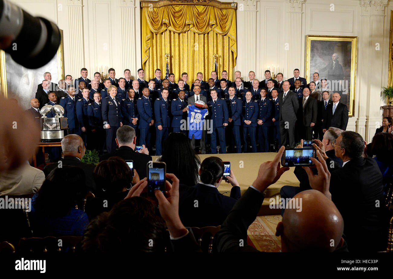 President Barack Obama accepts a football jersey and ball from the U.S ...