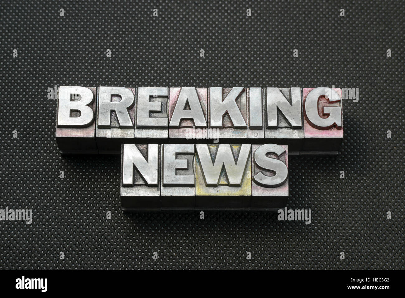 breaking news phrase made from metallic letterpress blocks on black ...