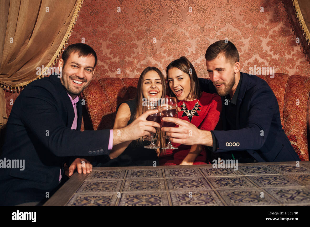 Two happy smiling young couples with champagne at celebration Stock ...