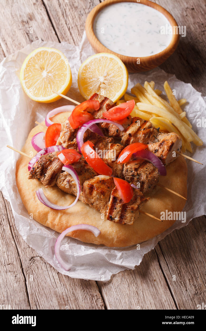 Greek souvlaki kebab with tomatoes, onions and french fries on pita ...