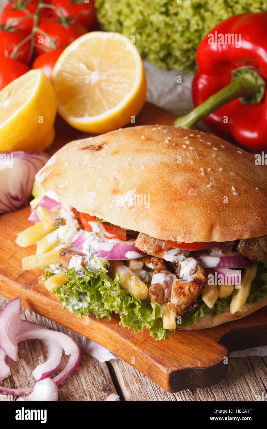 Doner kebab with meat and vegetables in pita bread closeup. Vertical ...