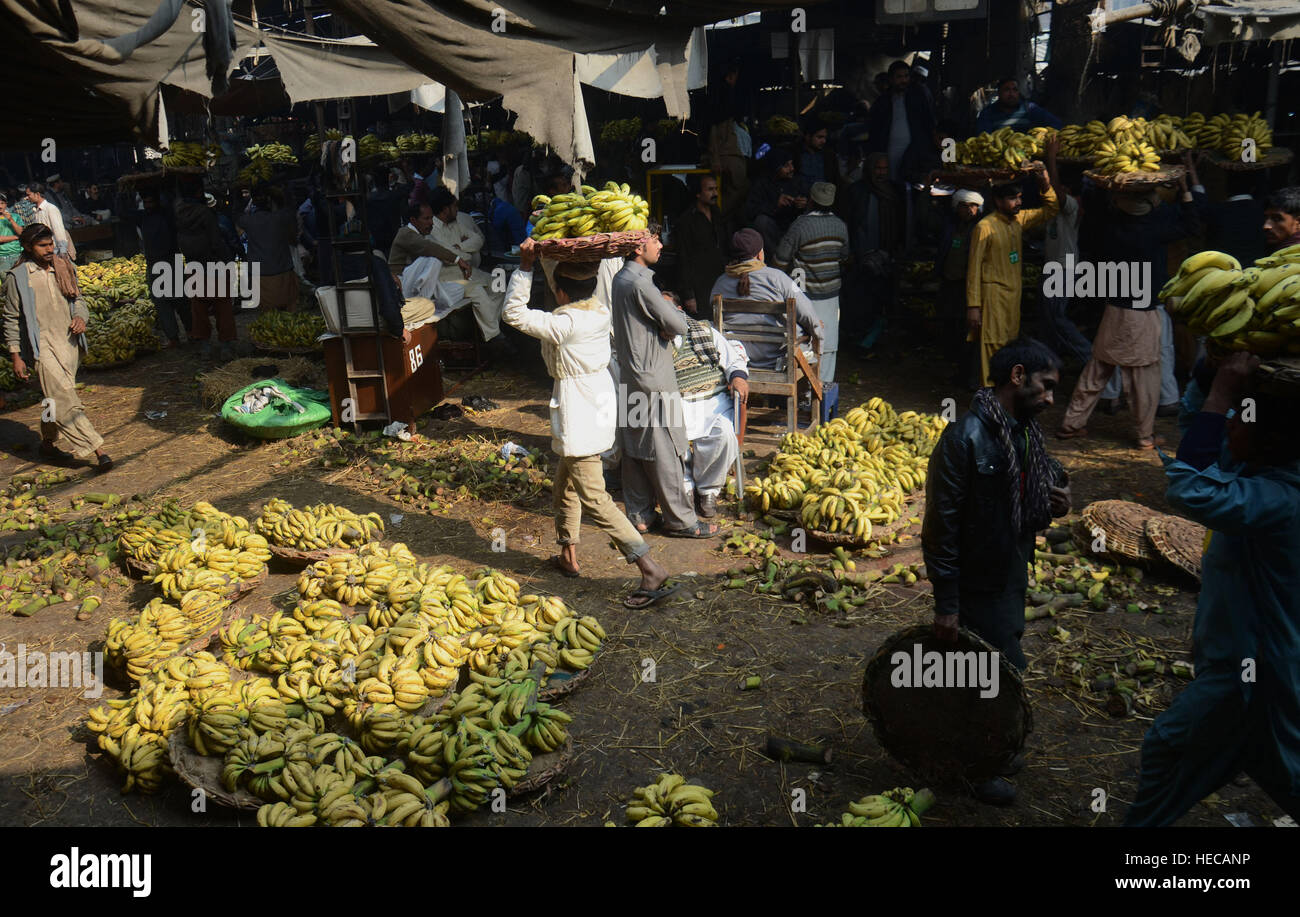 Lahore, Pakistan. 19th Dec, 2016. Pakistani laborers carry baskets of ...