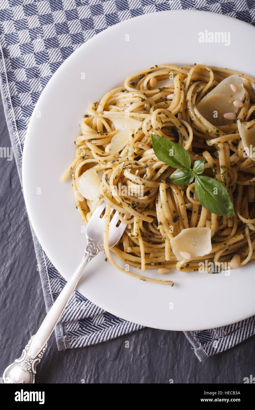 pasta with pesto, pine nuts and parmesan close-up on a white plate ...