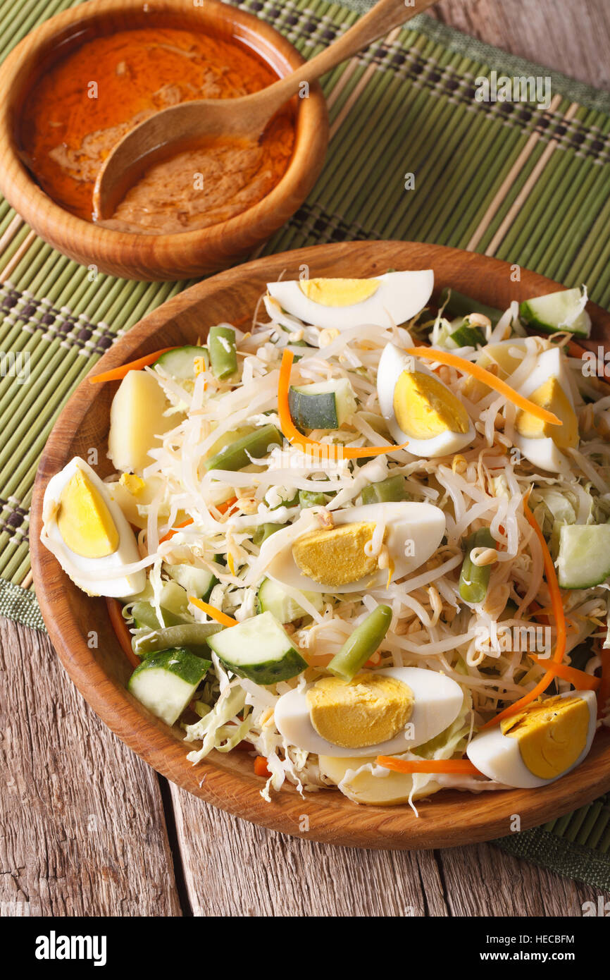 Gado Gado Indonesian vegetable salad close-up on the table. Vertical ...