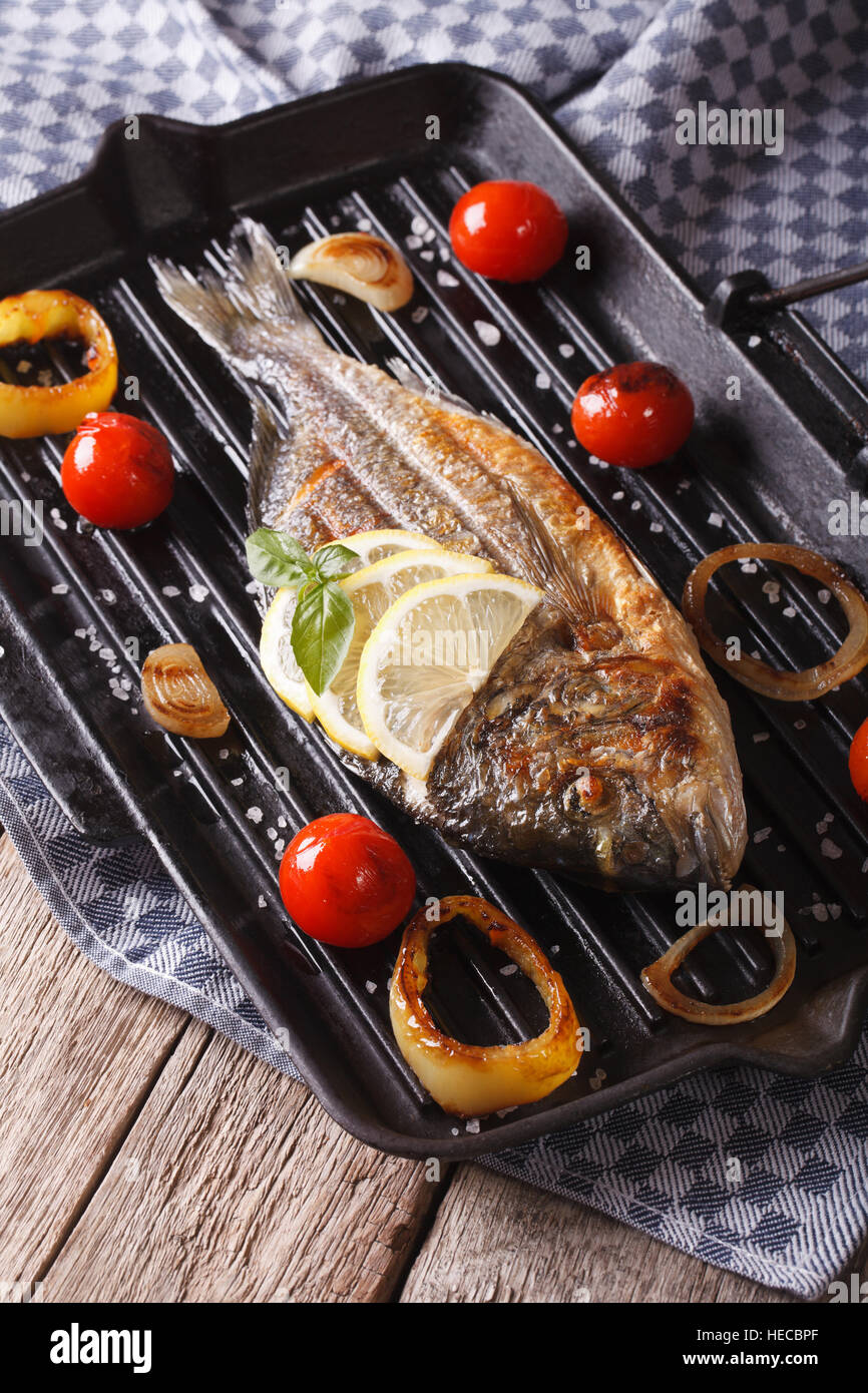 Grilled dorado fish with vegetables close up on a grill pan on the ...