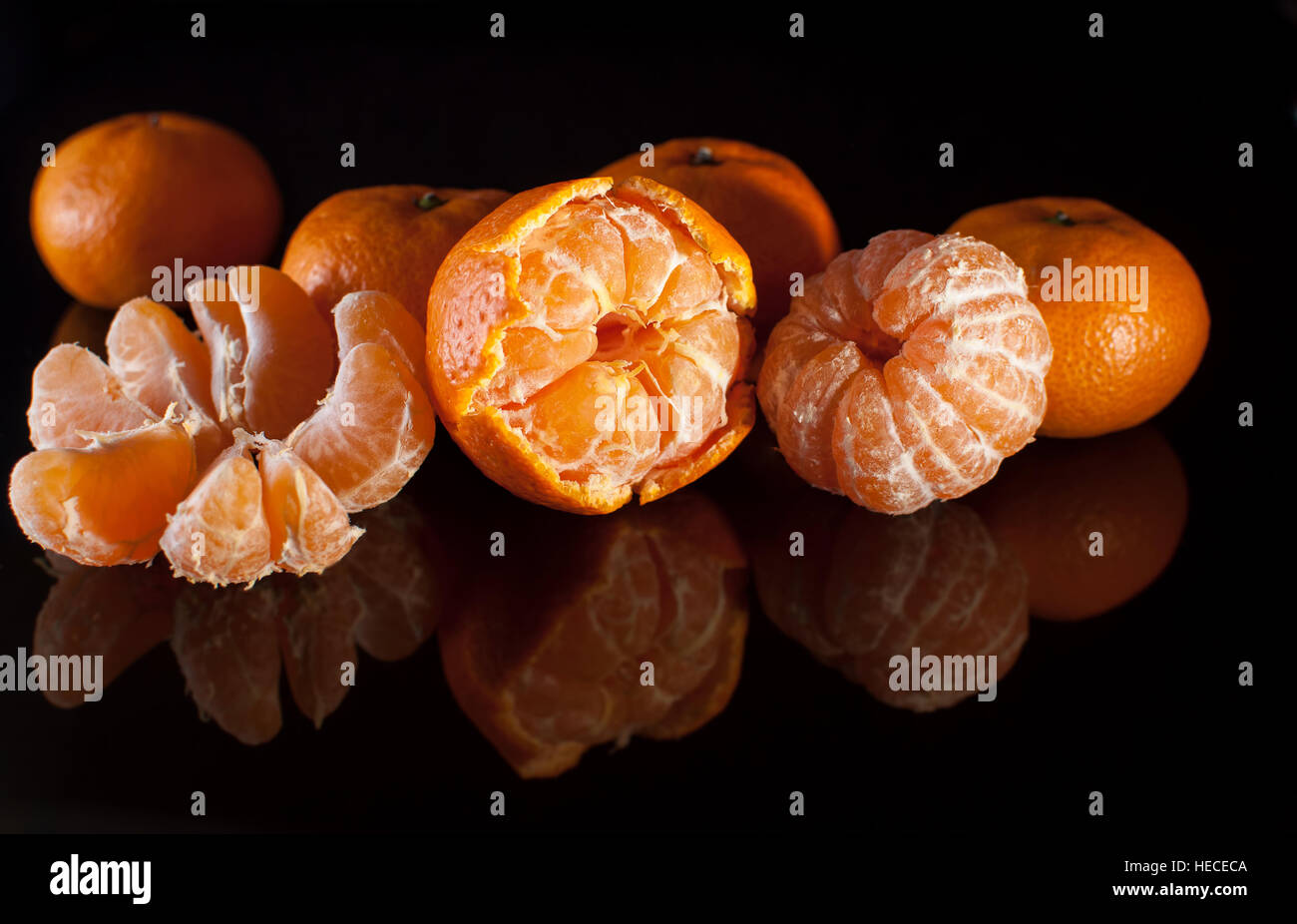 Group of mandarins with mirror reflection on black background close up ...
