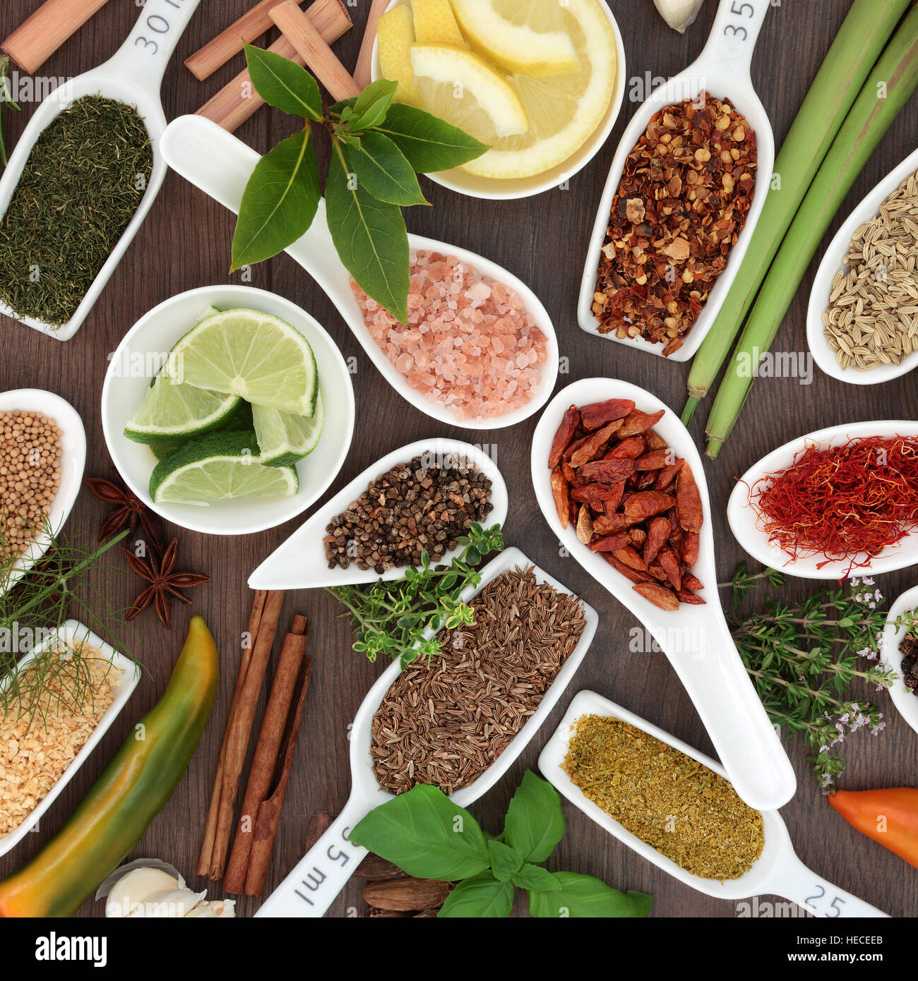 Spice and herb seasoning in porcelain spoons and scoops on oak ...