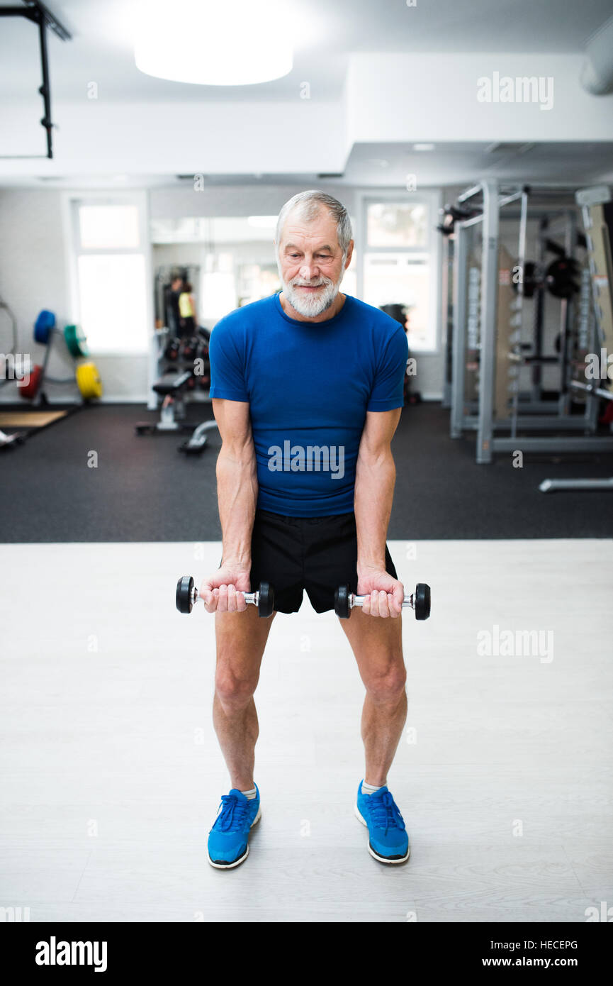 Senior man in sports clothing in gym working out with weights Stock ...