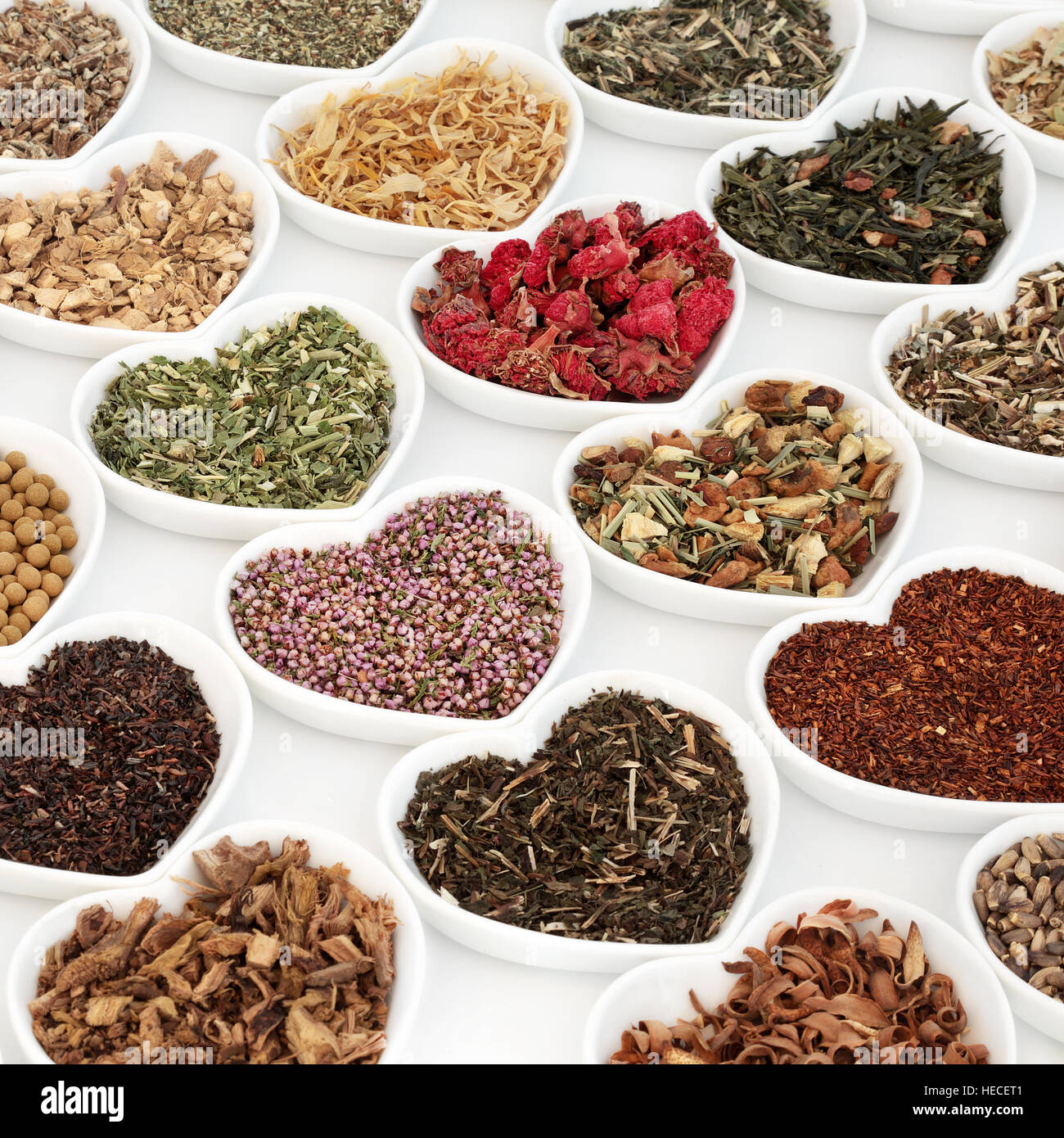 Herb tea collection in heart shaped china bowls over white background ...