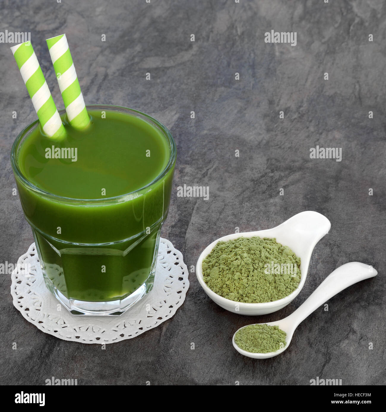 Wheat grass heath drink with supplement powder in a porcelain bowl and ...