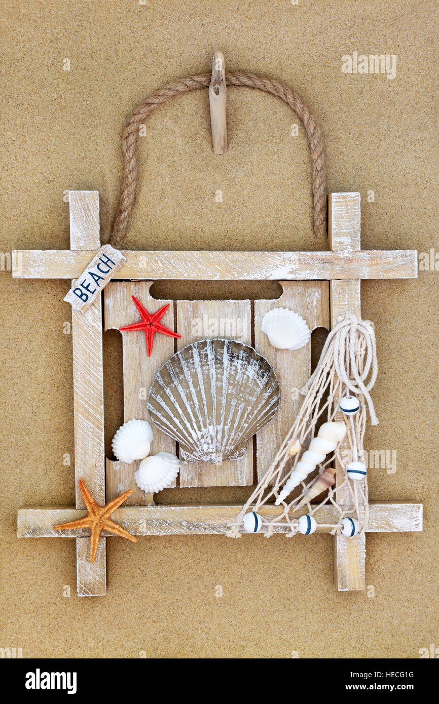 Rustic wooden beach sign with seashell selection on sand background ...