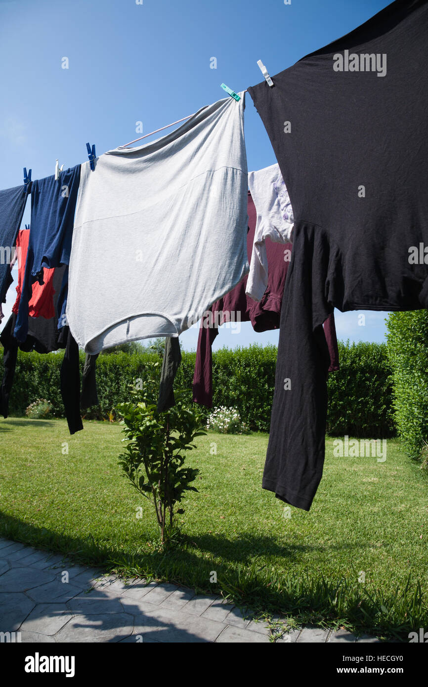 exterior clothesline with colorful shirts adult and baby clothes in ...