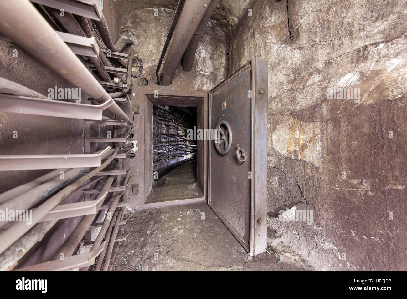 Old reinforced security door in an underground communication tunnel ...