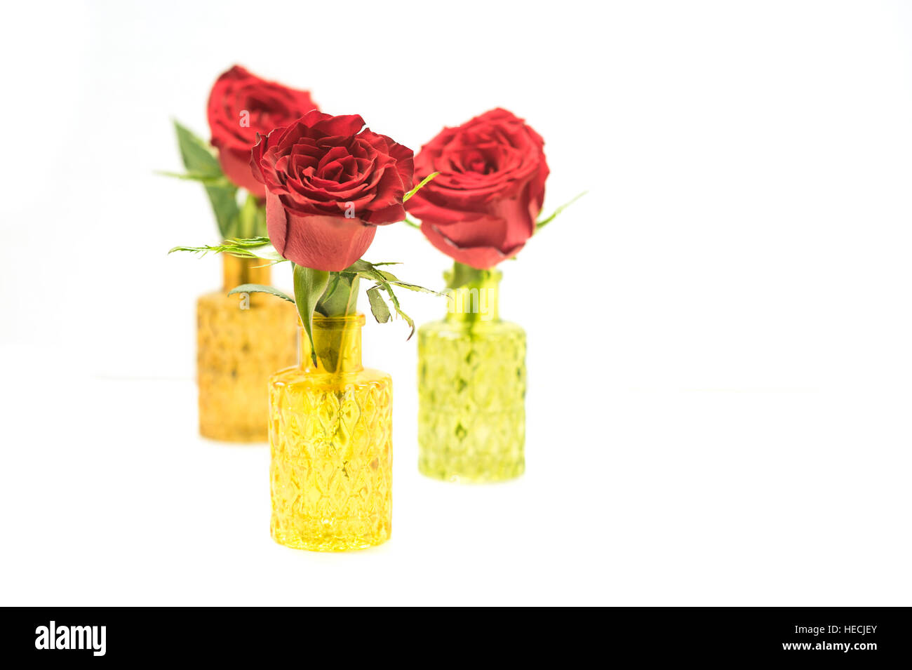 Close up of three red roses in glass vases Stock Photo - Alamy