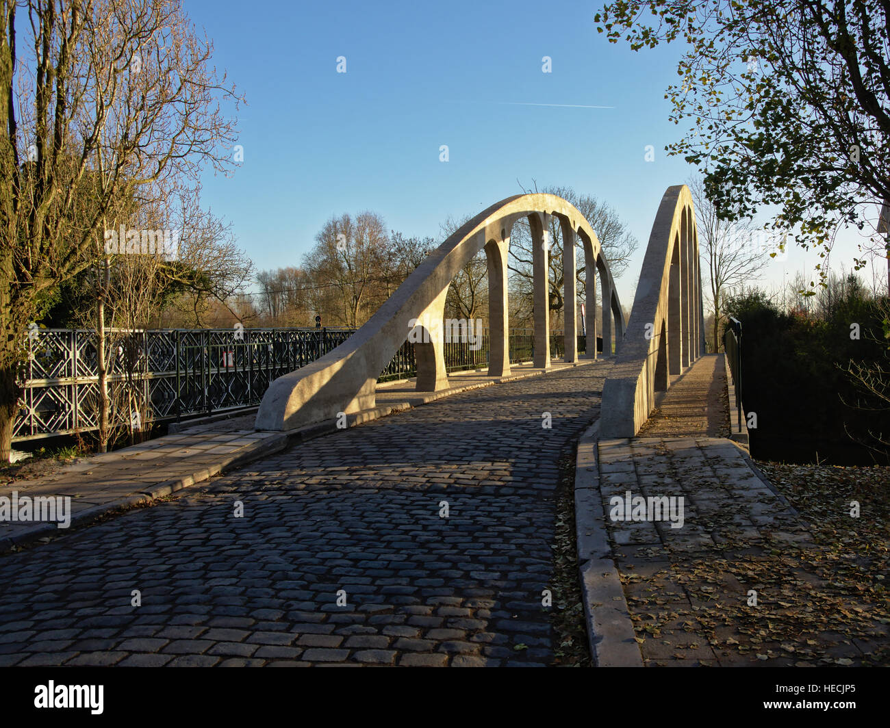 Cobblestone road over old tied arch bridge in the Flemish countryside ...
