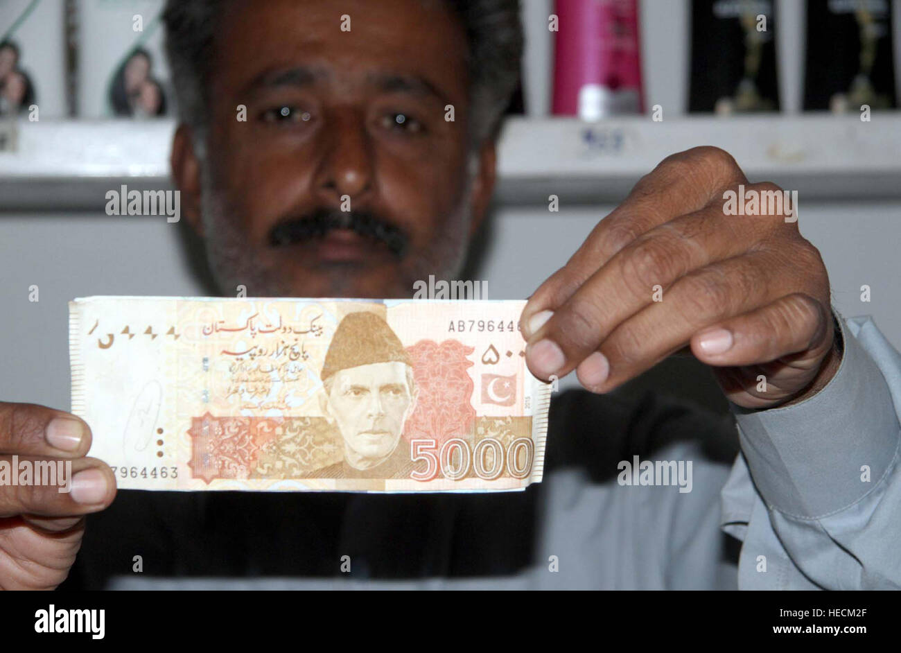 Currency dealer shows Rs. 5000 note, in Karachi on Monday, December 19 ...