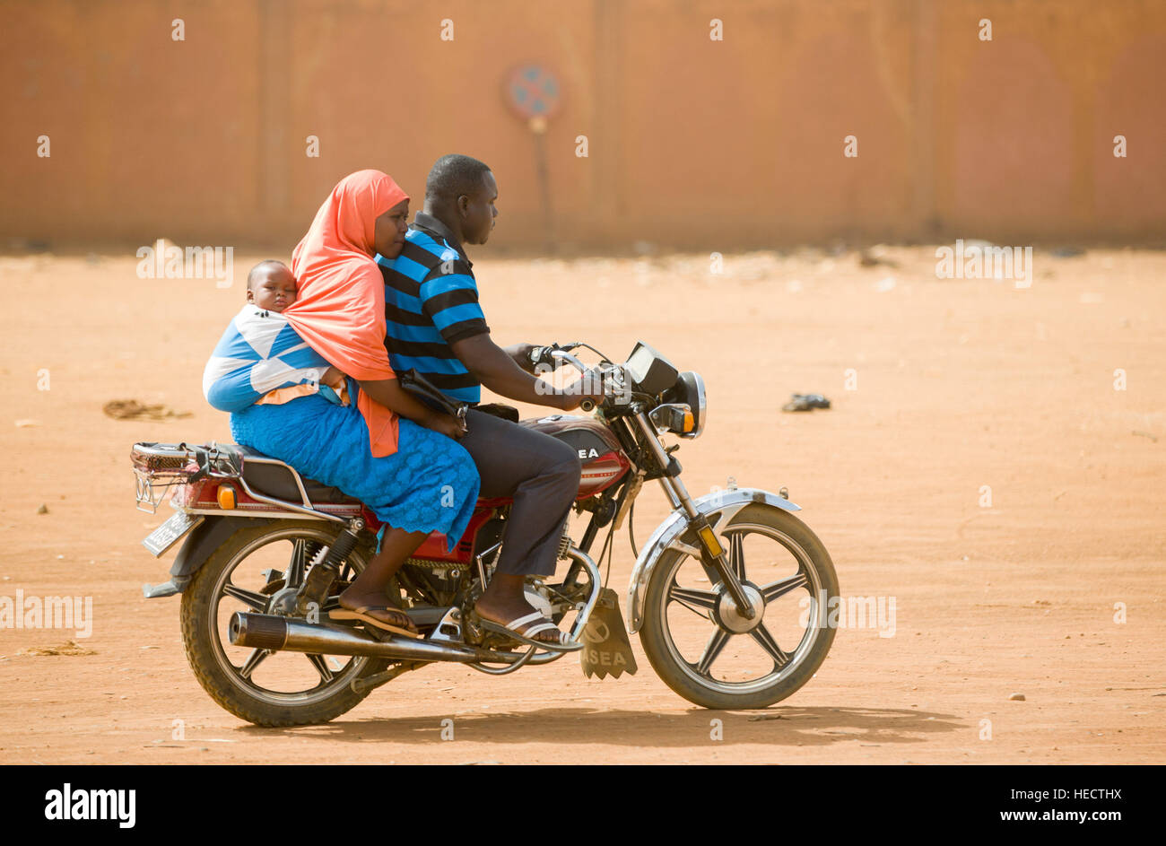 Niamey, Niger. 20th Dec, 2016. A family rides a motorcycle along a ...