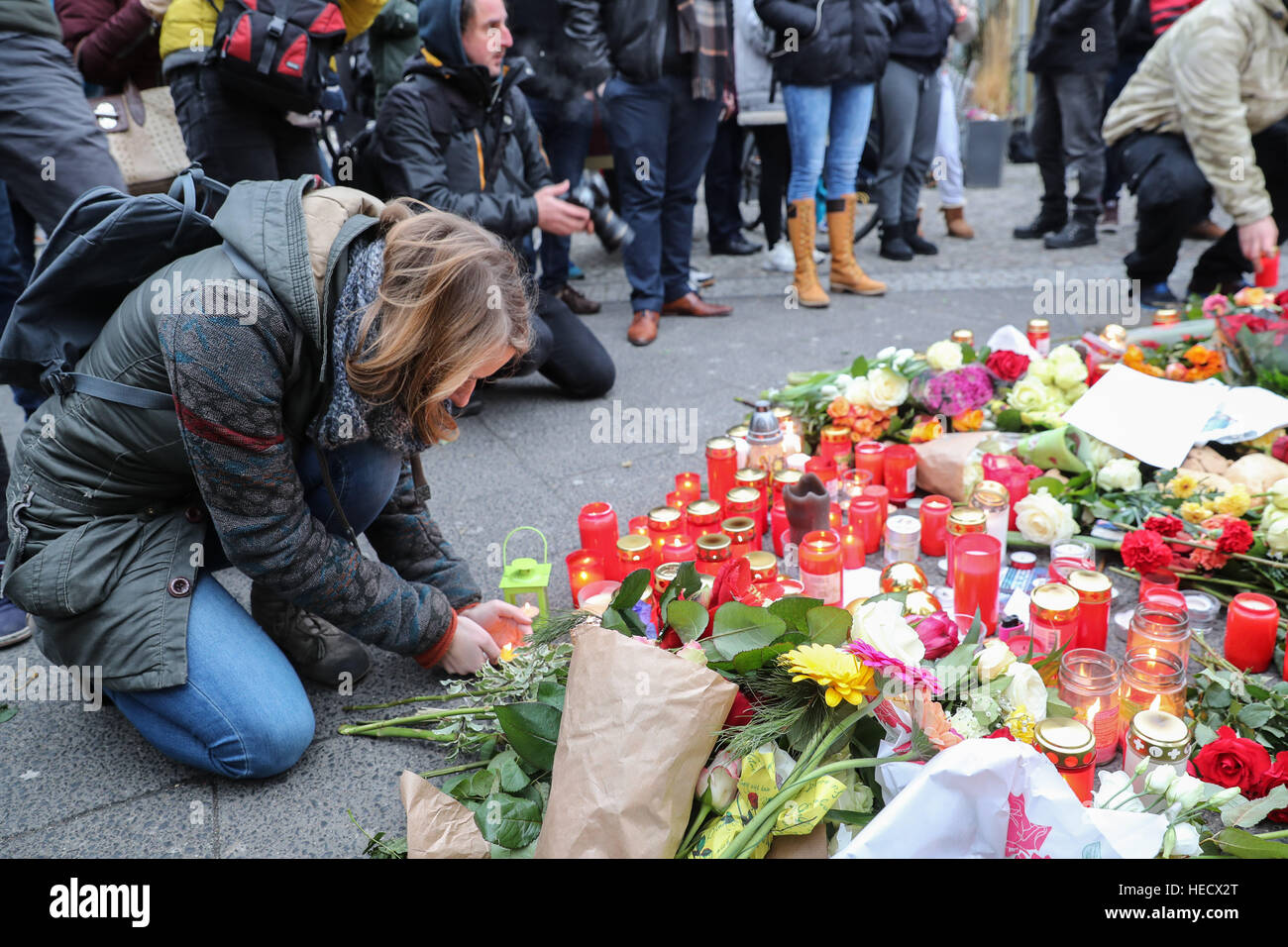 Berlin, Germany. 20th Dec, 2016. A woman lights a candle to mourn the ...