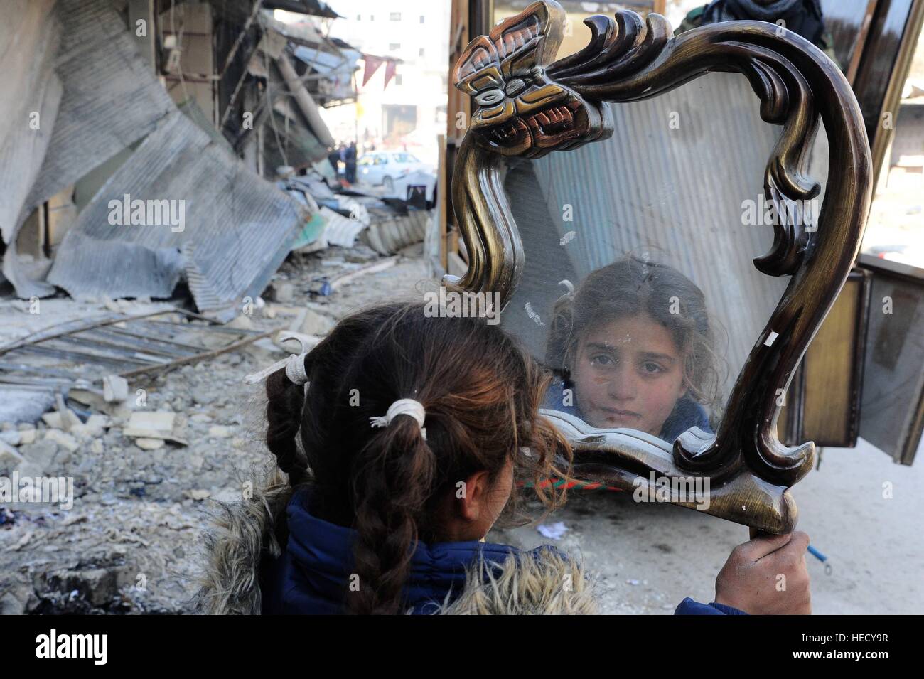 Aleppo, Syria. 20th Dec, 2016. A Syrian girl looks in the mirror at her ...