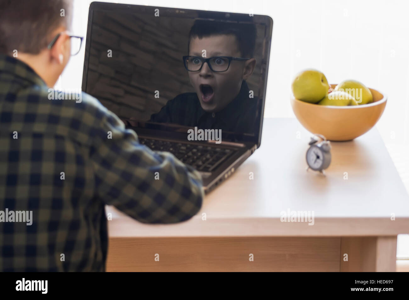 Shocked Boy With Glasses Using Laptop Computer While Sitting on Desk at ...