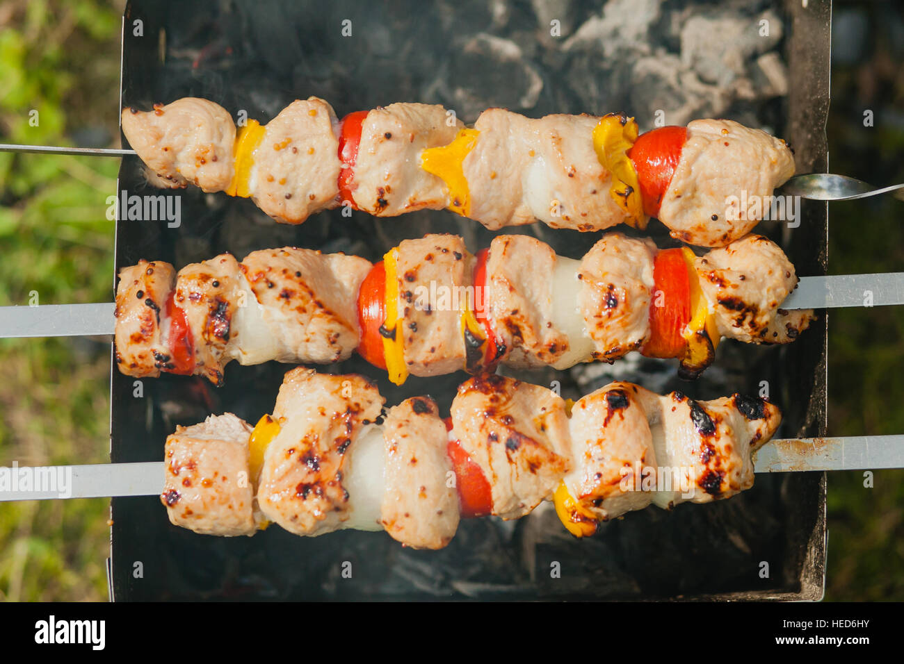 Meat skewers being grilled in a barbecue Stock Photo - Alamy