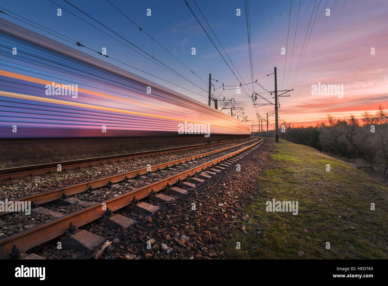High speed passenger train in motion on railroad track at sunset ...
