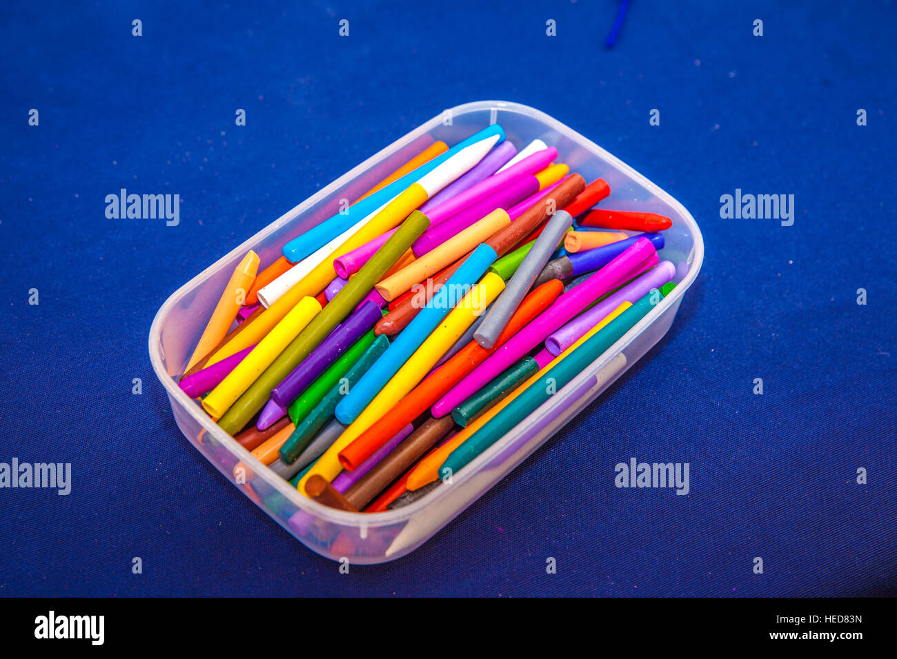 box full of colored crayons on a blue table Stock Photo - Alamy