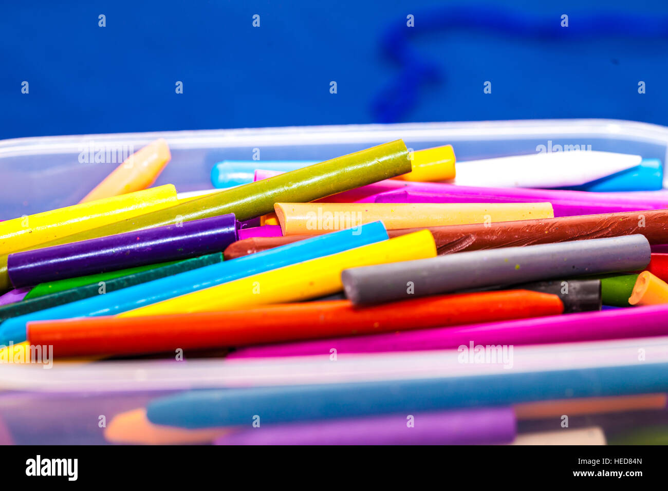 box full of colored crayons on a blue table Stock Photo - Alamy