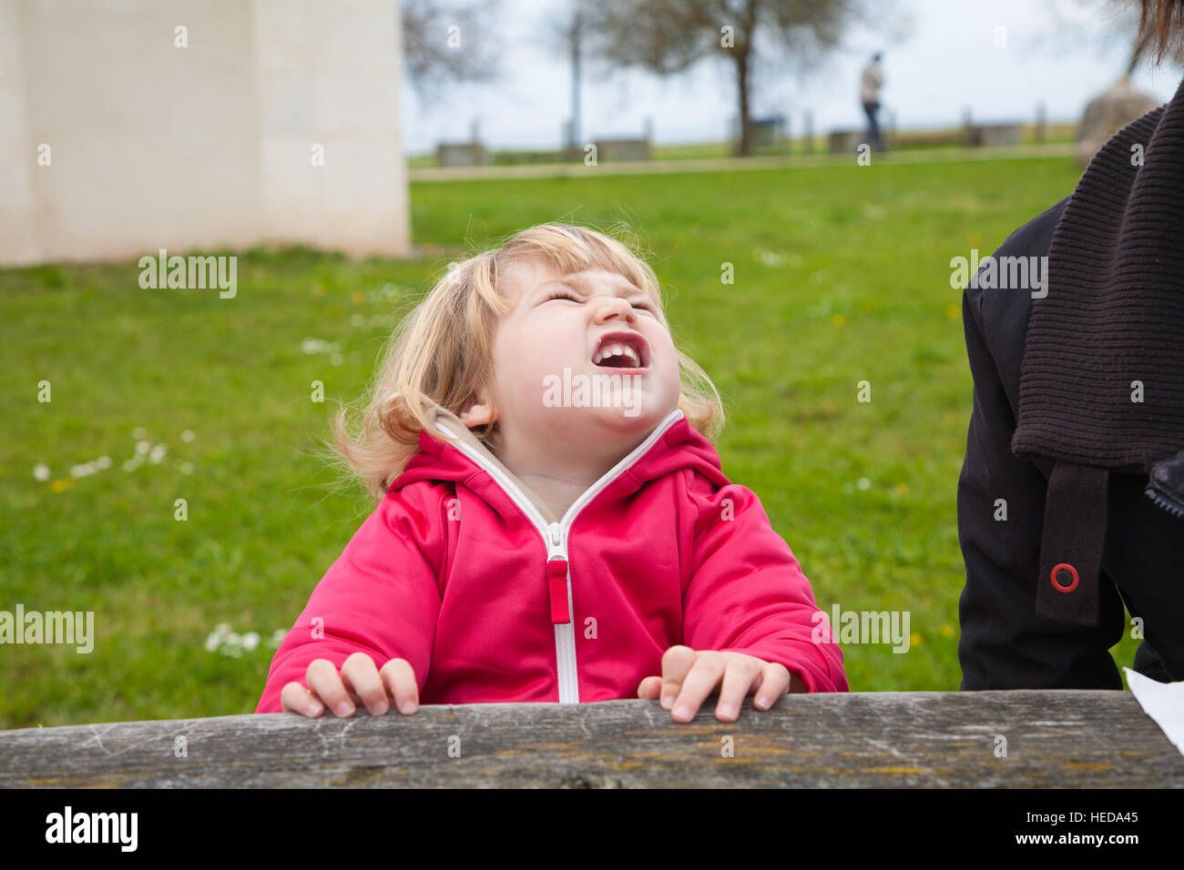 little blonde cute child sitting open mouth screaming and shouting ...