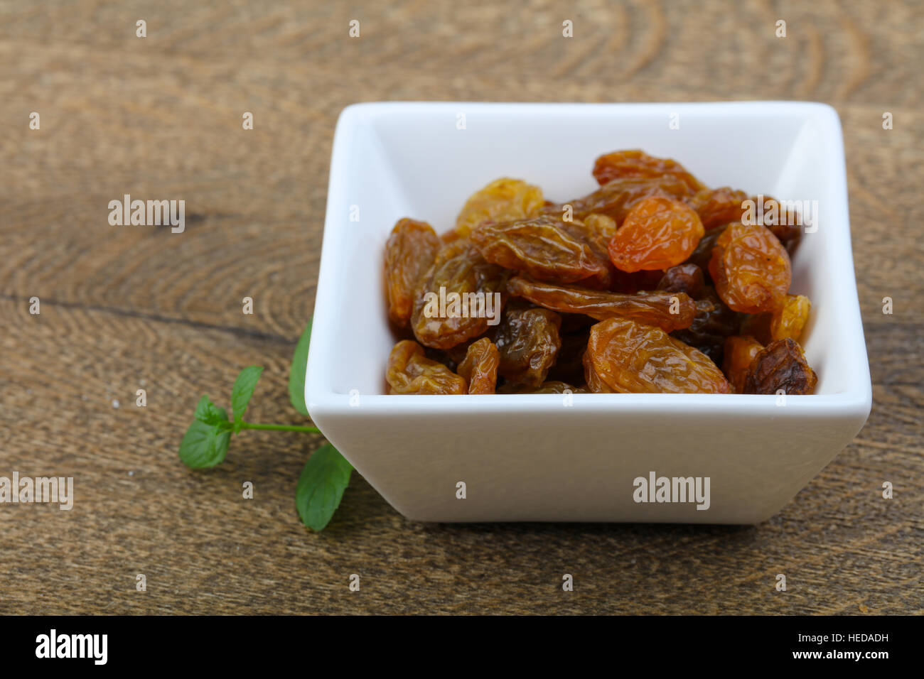 Sweet raisins in the bowl with mint leaves Stock Photo - Alamy